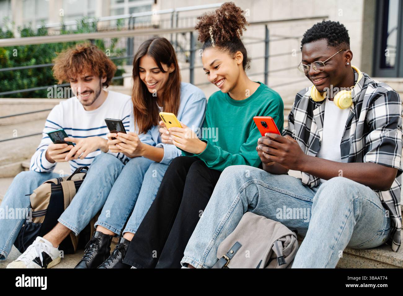 Cheerful group of diverse college students having fun using smartphones ...