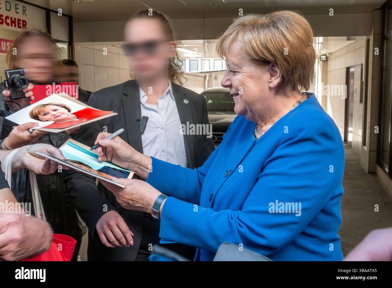 Angela Merkel, Ex-Bundeskanzlerin, gibt wartenden Fans Autogramme, nach ...