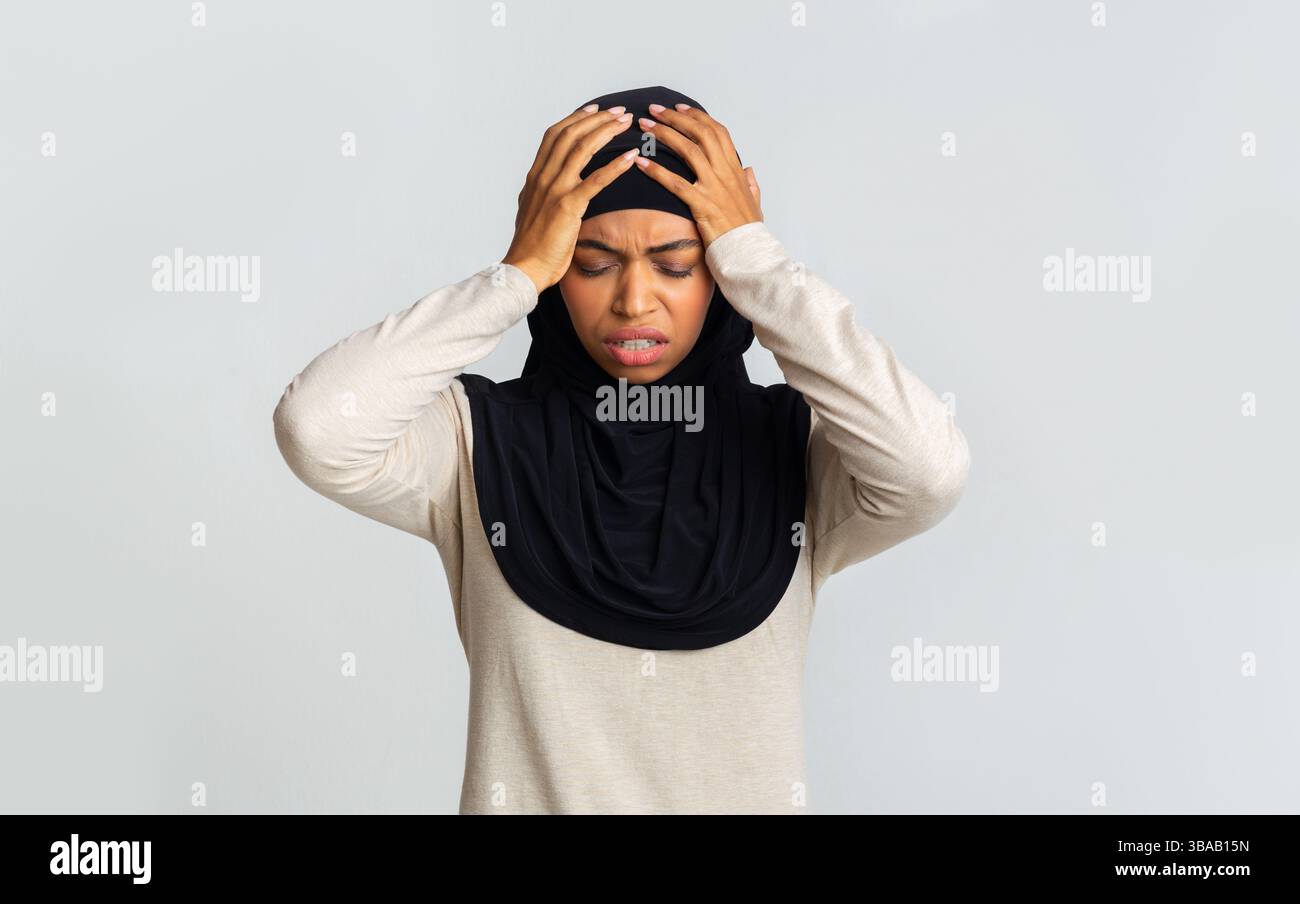 Acute headache. Sick black muslim lady in headscarf touching her head ...