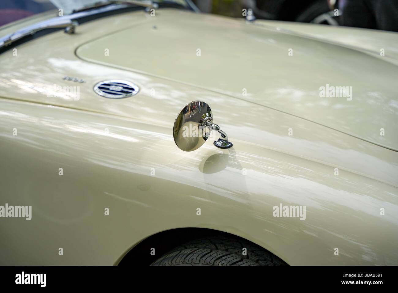 Cream-colored classic car with chrome side mirror. A vintage car in ...