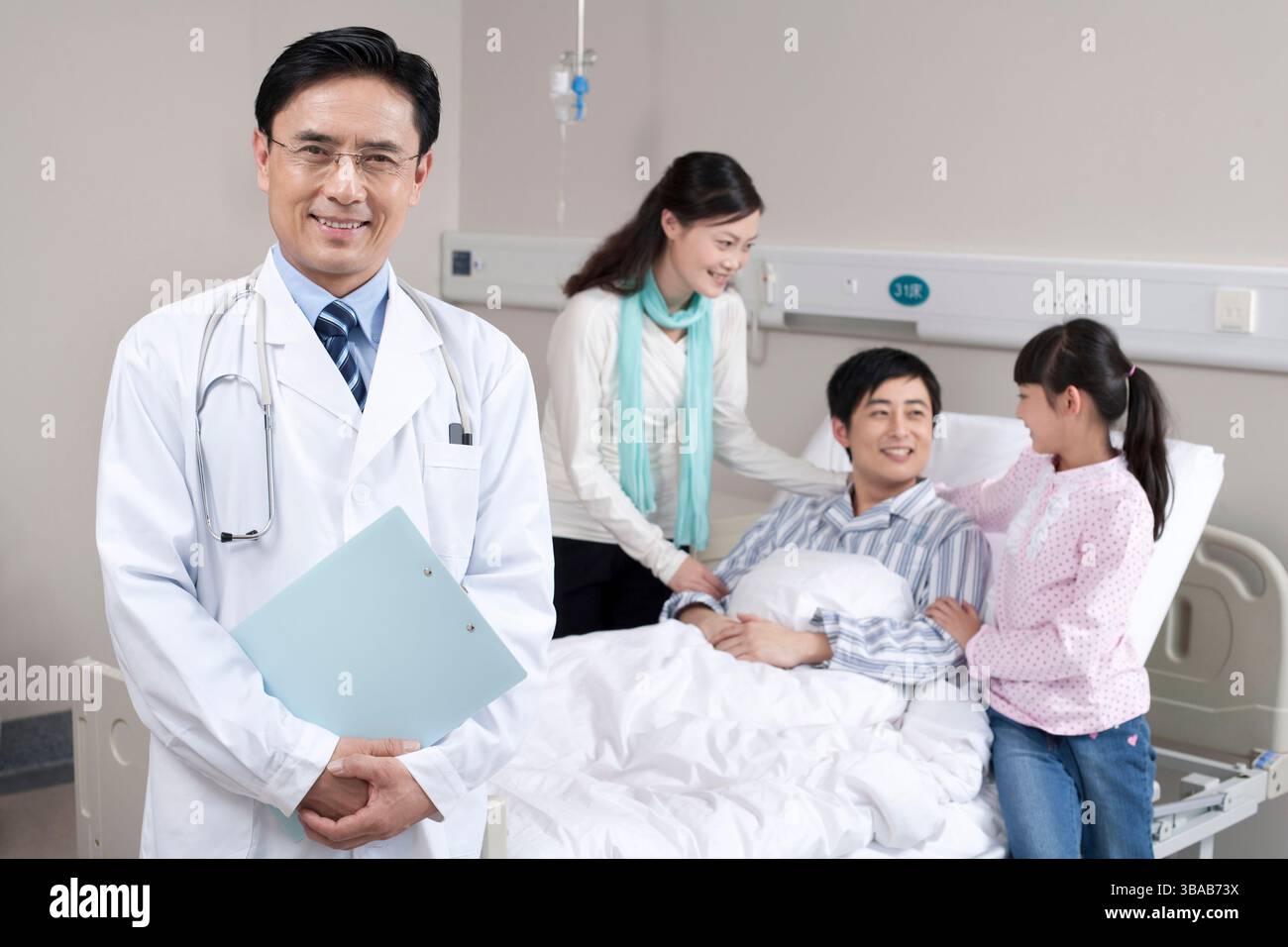 Portrait of male Chinese doctor with his patient and his patient's ...