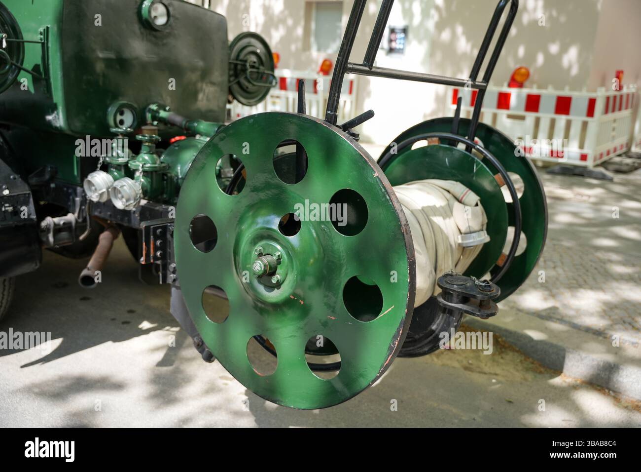 A large green hose reel. A hose reel with a coiled fire hose on a ...