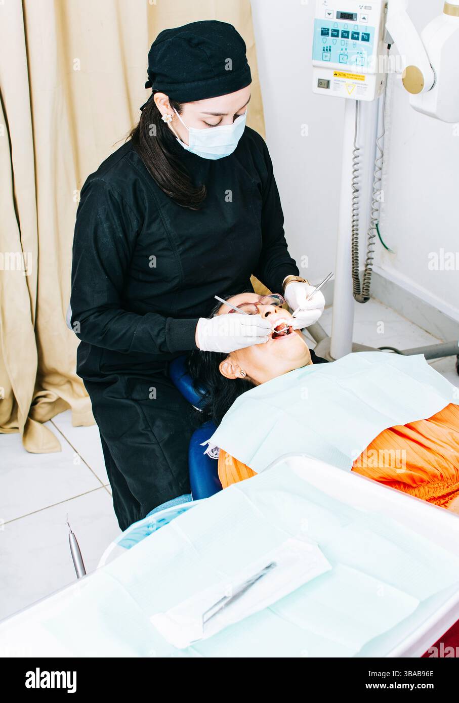 Nicaraguan female dentist wearing face mask and gloves using ...