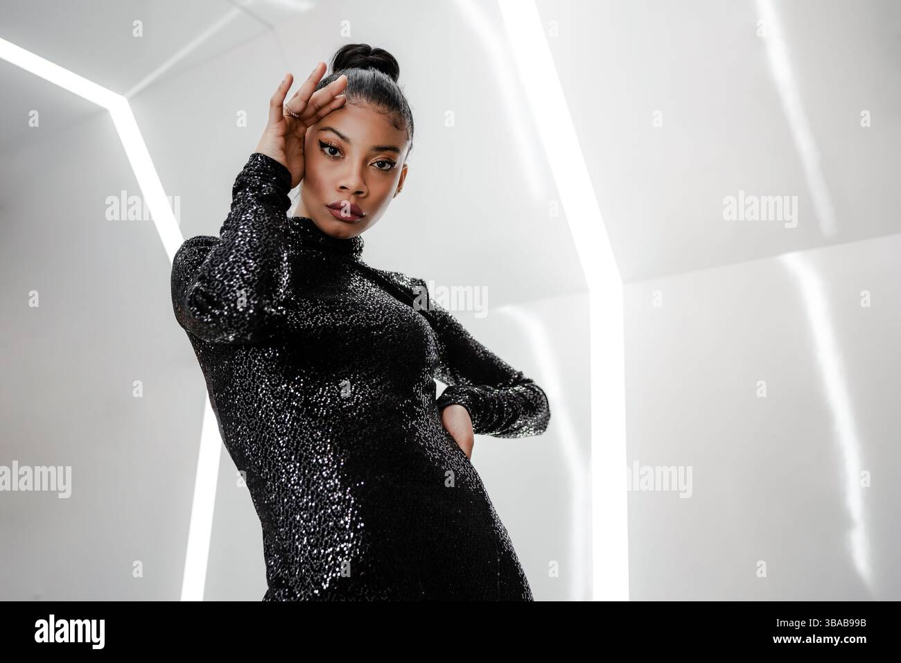 African American woman with hand on forehead standing against wall ...
