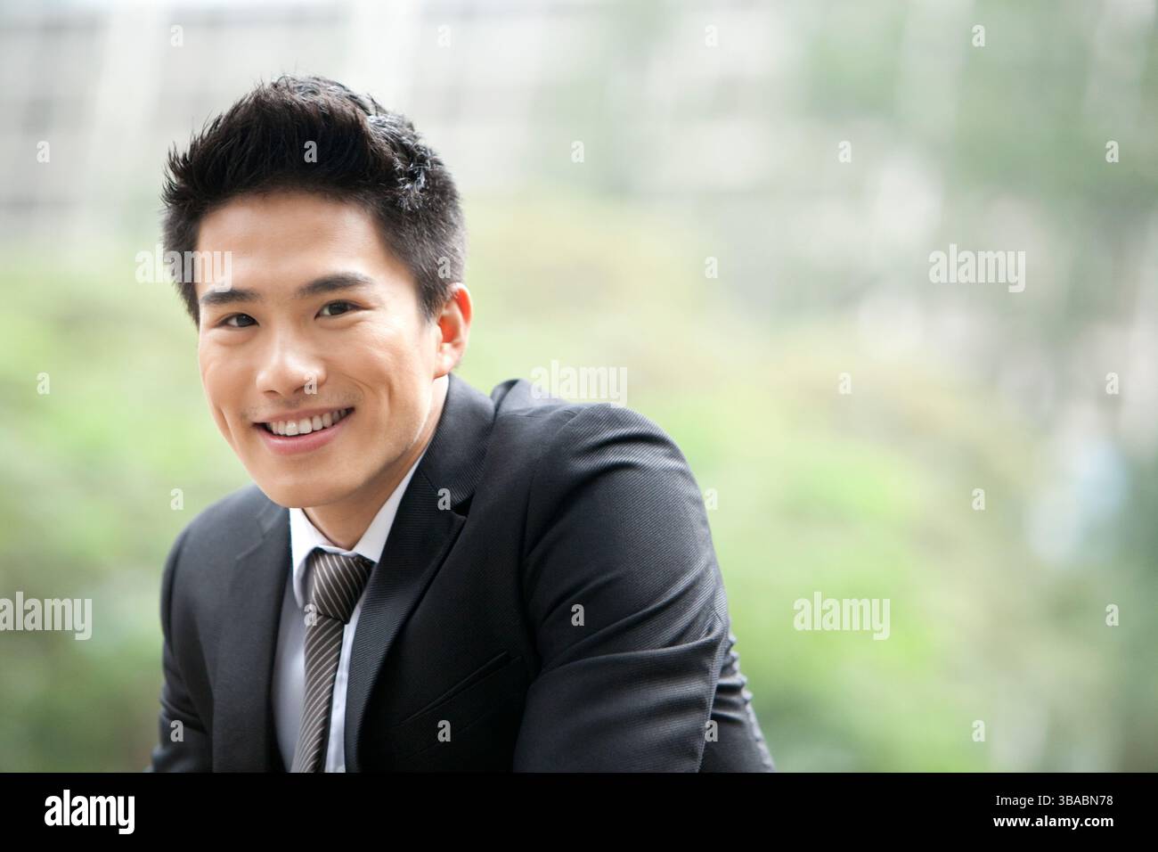 Portrait of cheerful young Chinese businessman outdoors, Hong Kong ...