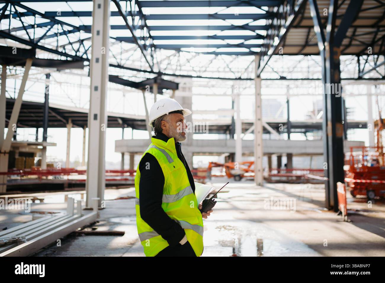 Construction foreman giving instructions over radio during building ...