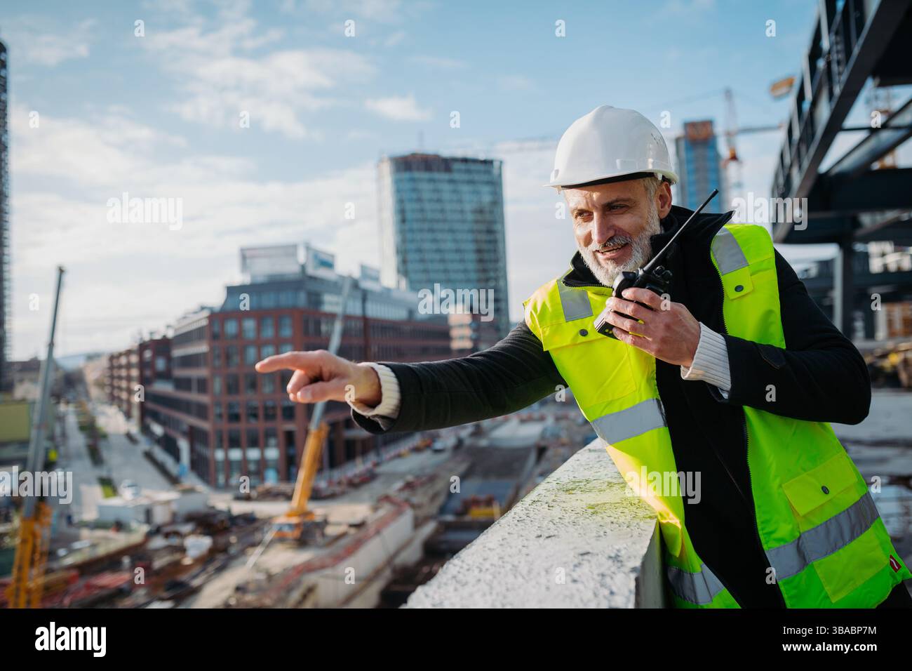 Site manager giving instructions over radio during building inspection ...