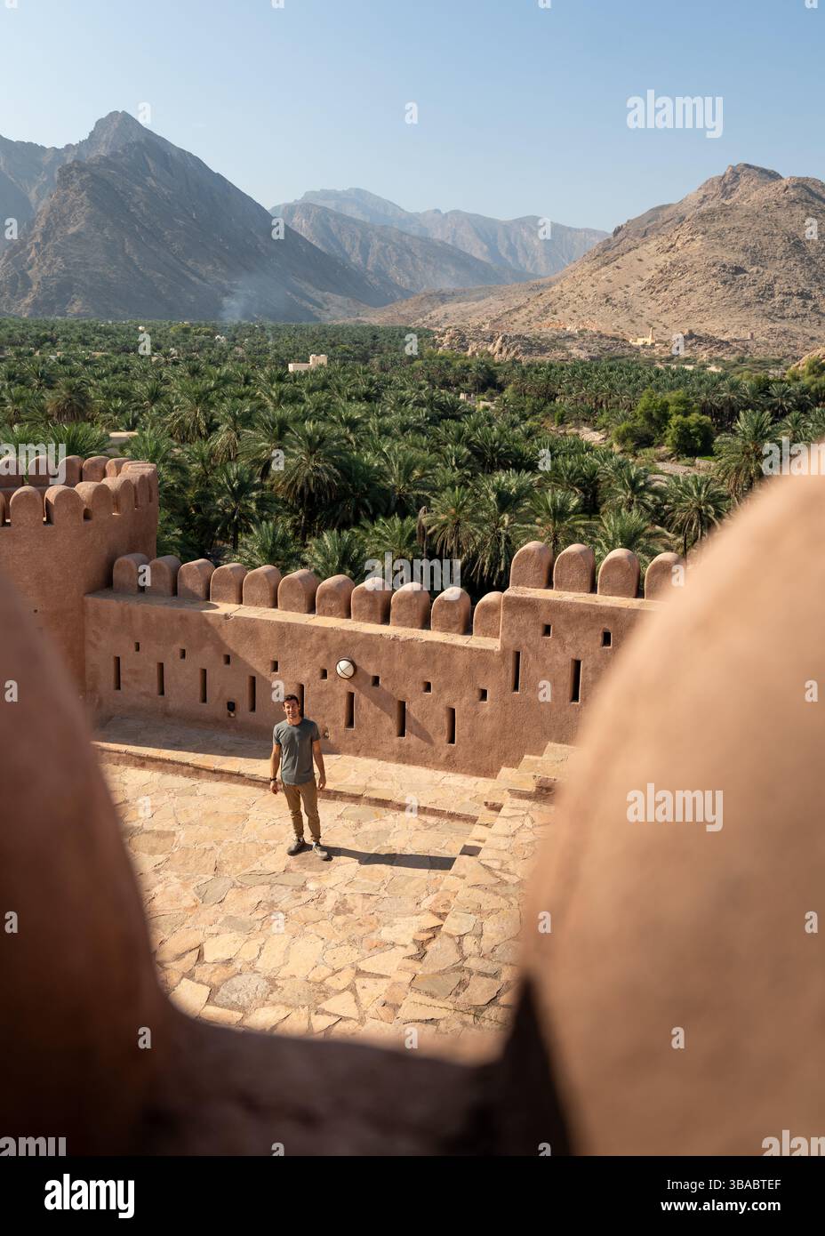 A man explores the historic Nakhal Fort in Oman, a stunning example of ...