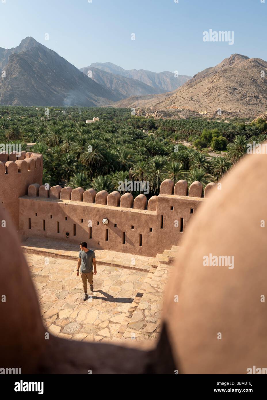 A man explores the historic Nakhal Fort in Oman, a stunning example of ...