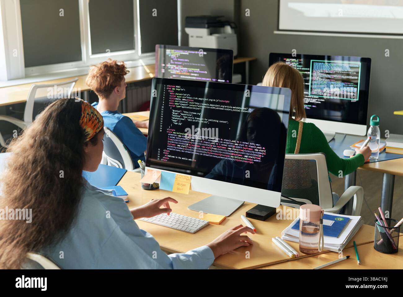 Group of students writing computer codes during lesson at school Stock ...
