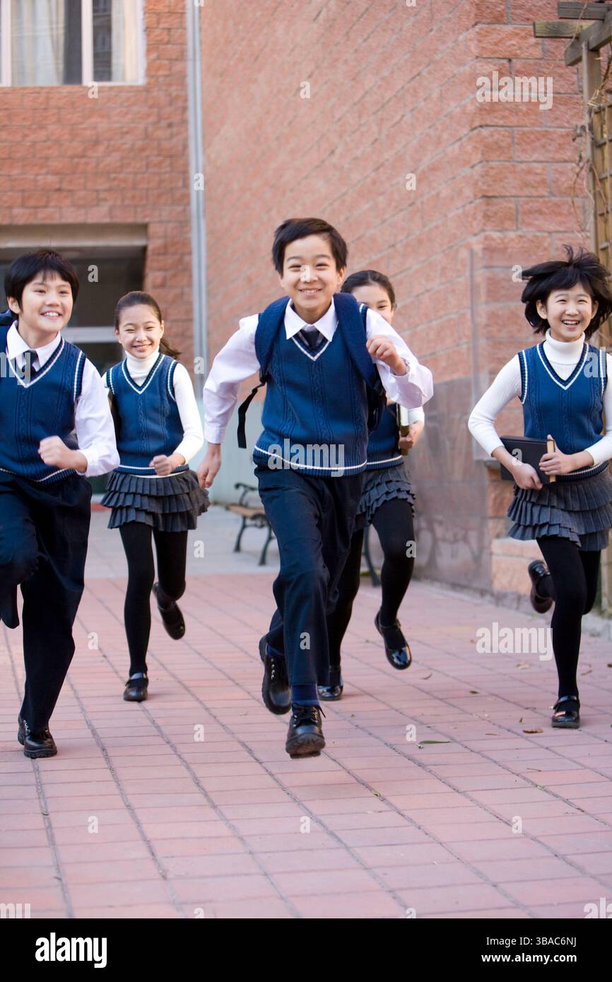 Five Chinese classmates running through campus Stock Photo - Alamy