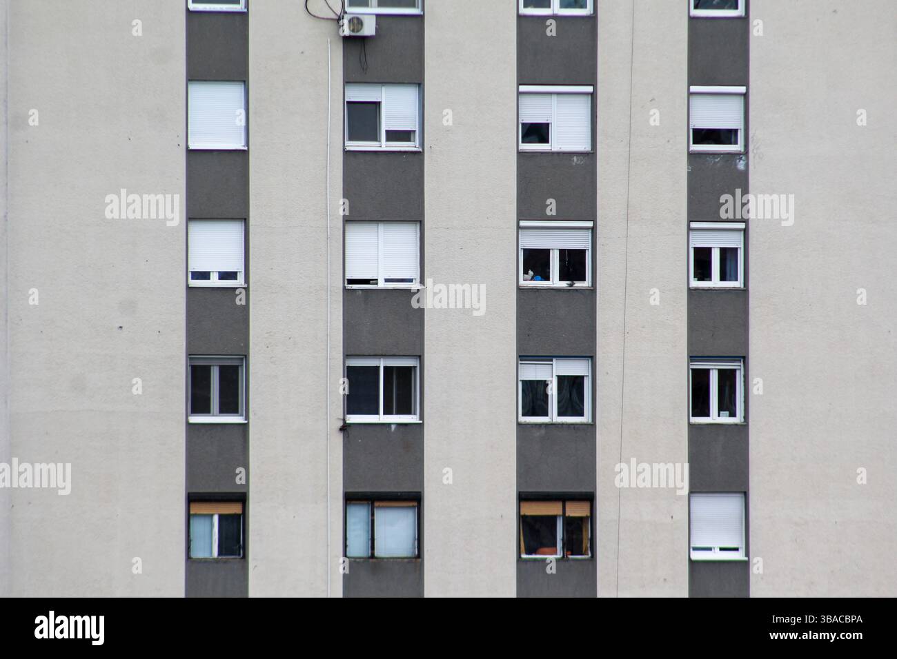 A close-up view of a tall residential building featuring various window ...