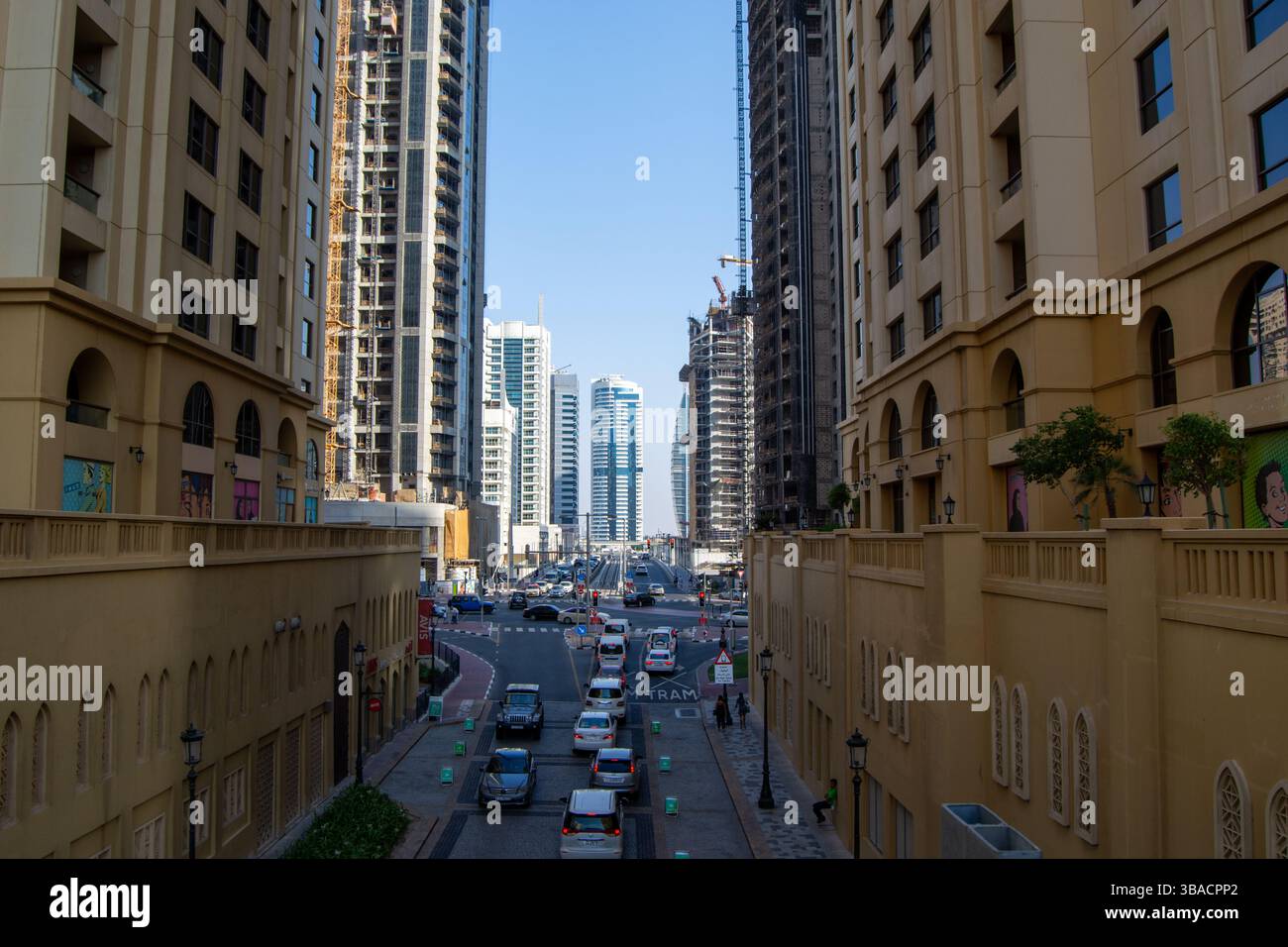 A view of a city street lined with tall buildings under construction ...