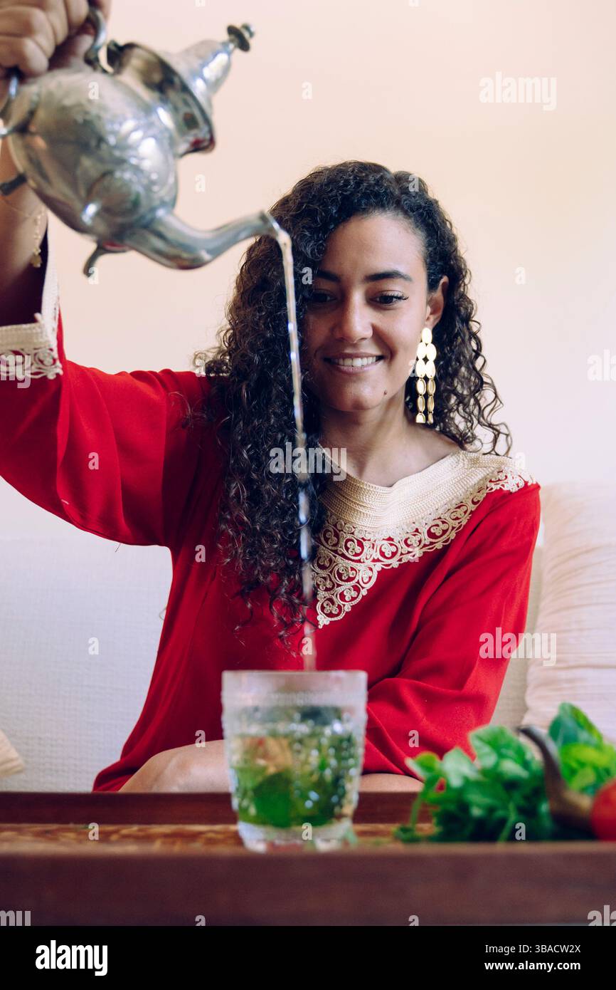 Moroccan green herbal tea poured with silver teapot in traditional ways ...