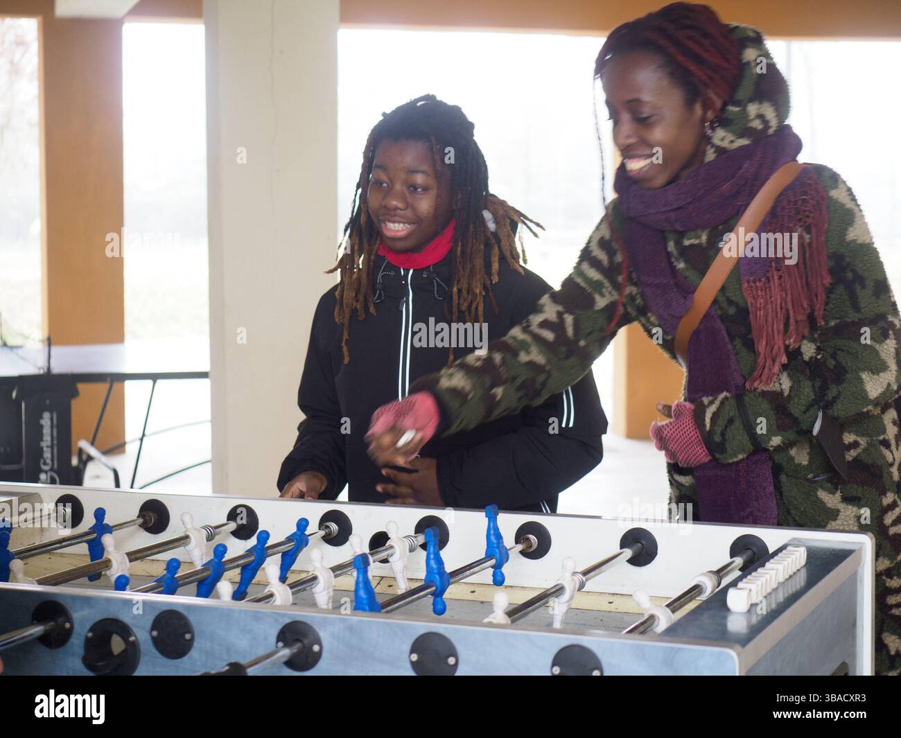 Black female teenager with dreads wearing hoodie jacket touching ...