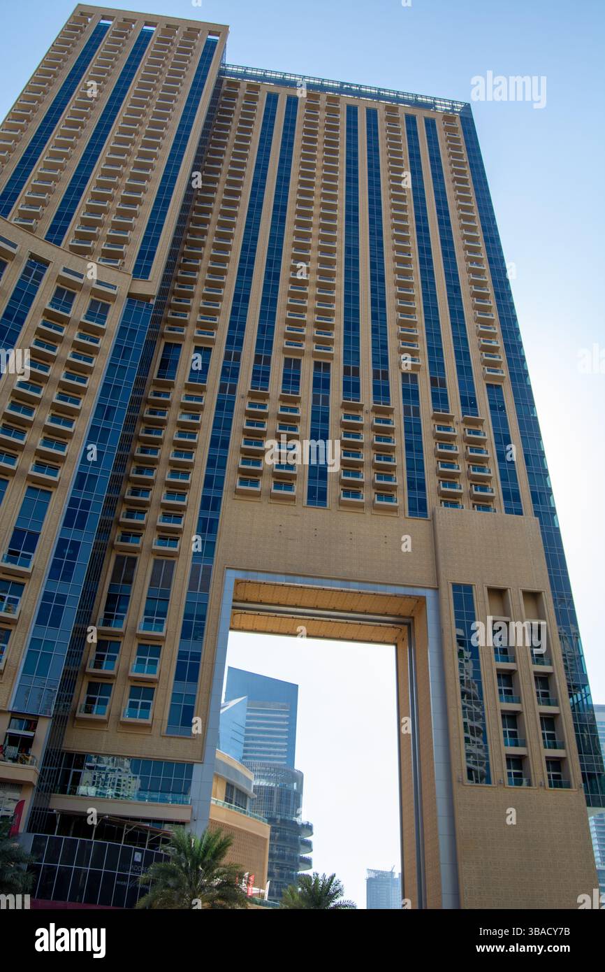 A tall modern skyscraper with a unique architectural design featuring a ...