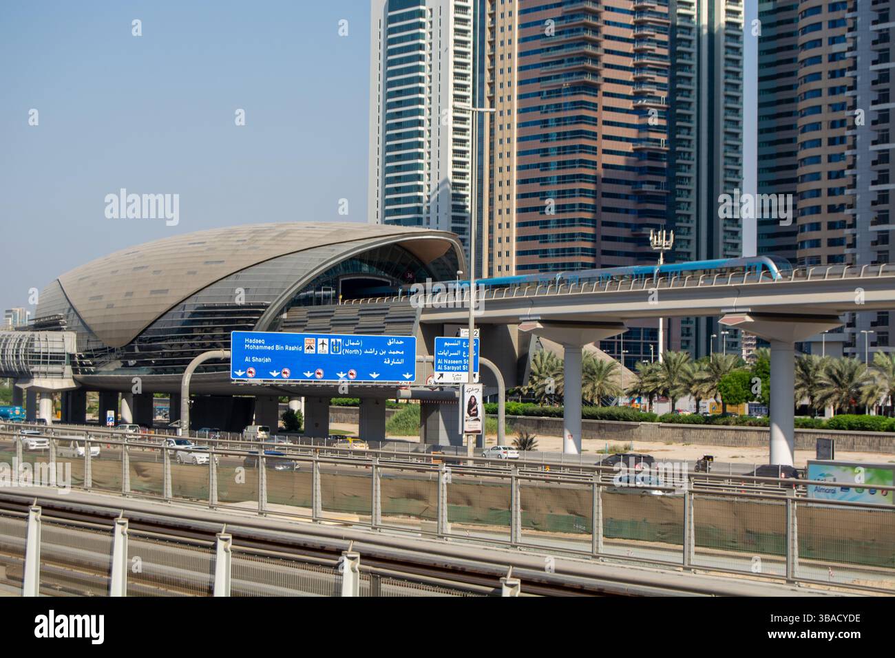 A modern metro station with a sleek, curved roof design, surrounded by ...