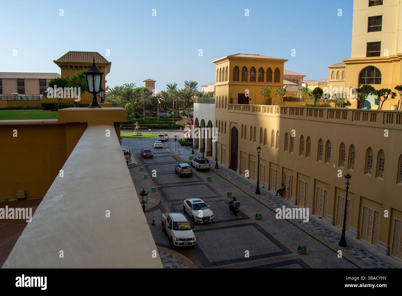 A scenic view of a well-maintained street lined with palm trees and ...