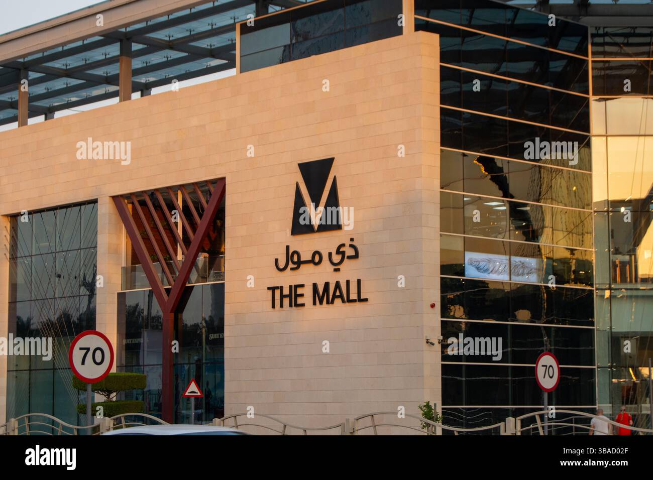 A modern shopping mall exterior featuring large glass windows and a ...