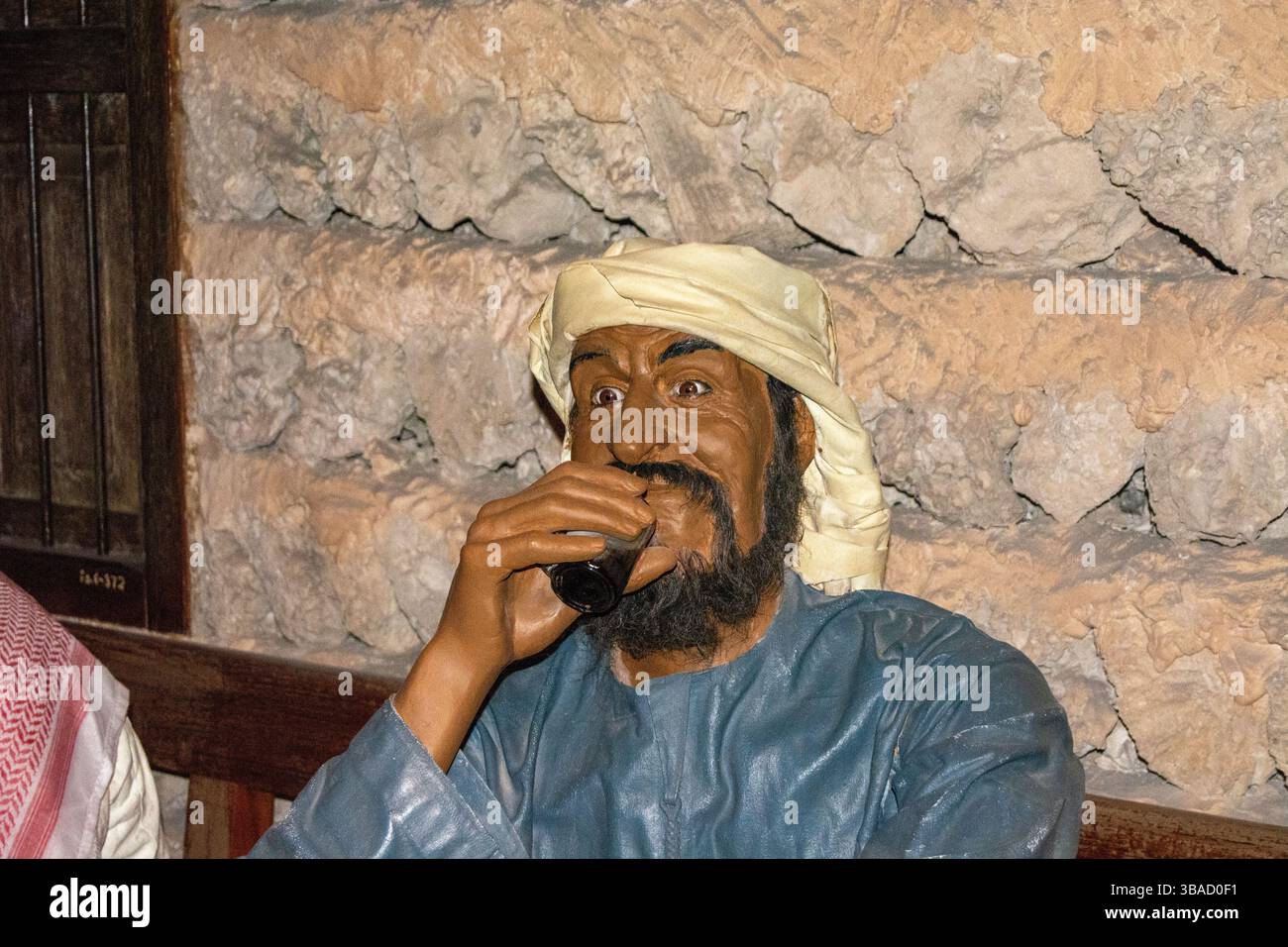 A lifelike statue of a man in traditional Middle Eastern attire ...