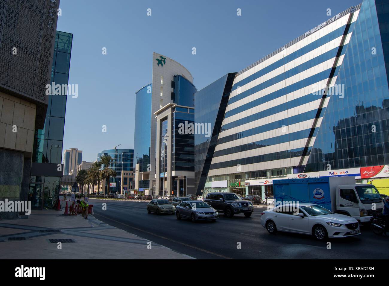 A busy urban street scene featuring modern buildings with glass facades ...