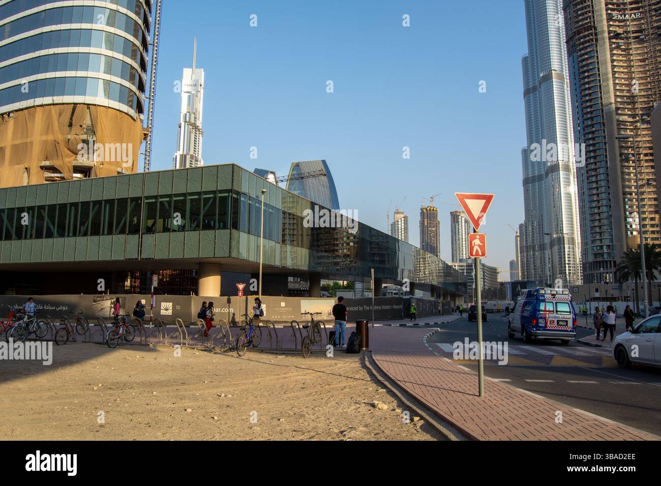 A modern urban scene featuring a large glass building under ...