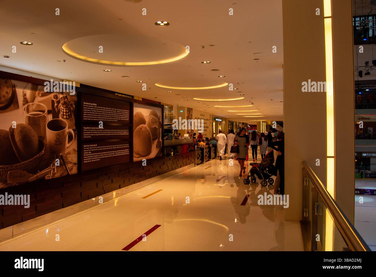 A modern shopping mall corridor with a glossy floor, illuminated ...