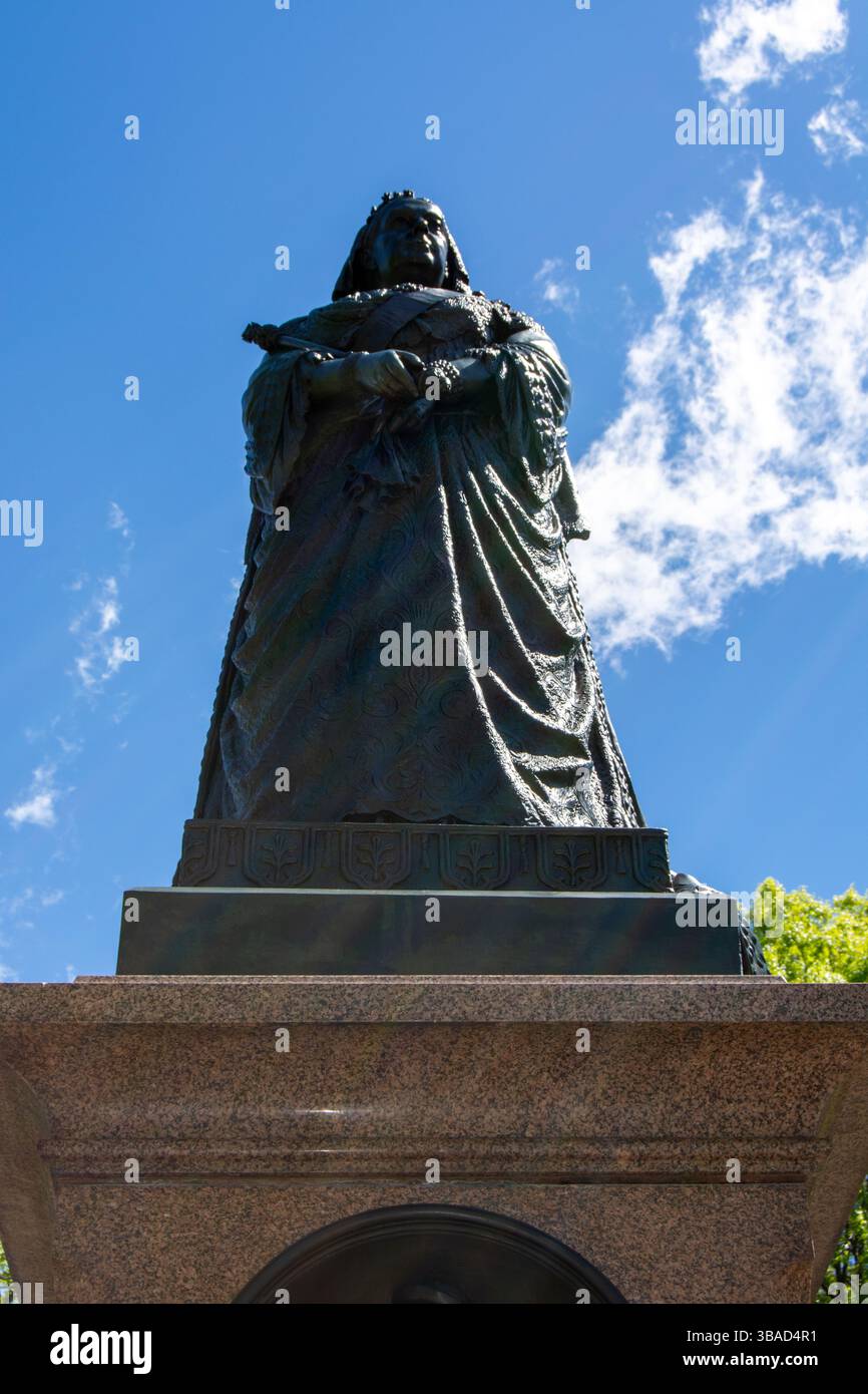 A bronze statue of a regal figure, draped in a flowing robe, standing ...