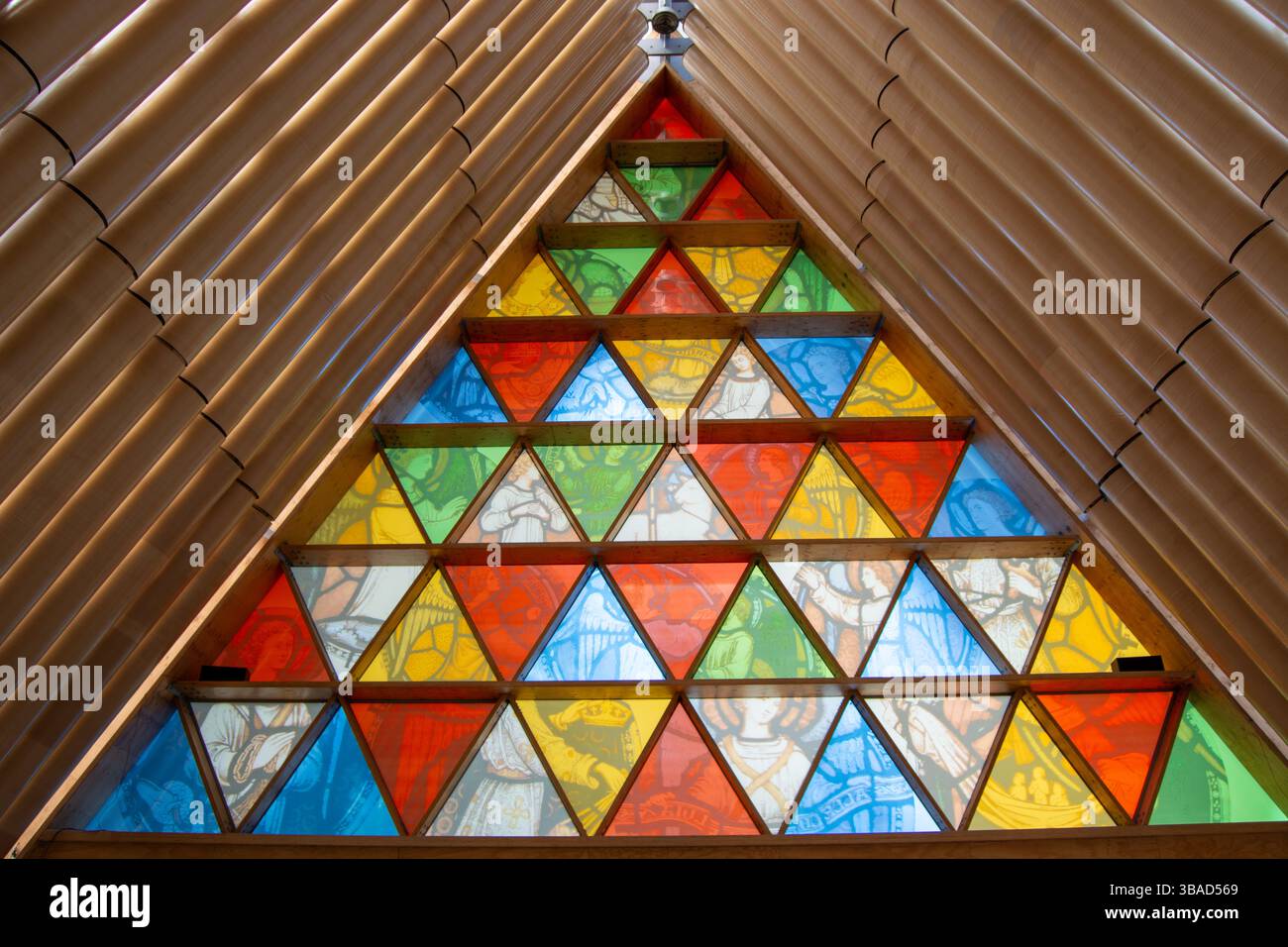 A colorful stained glass window featuring triangular patterns in a modern architectural setting ...