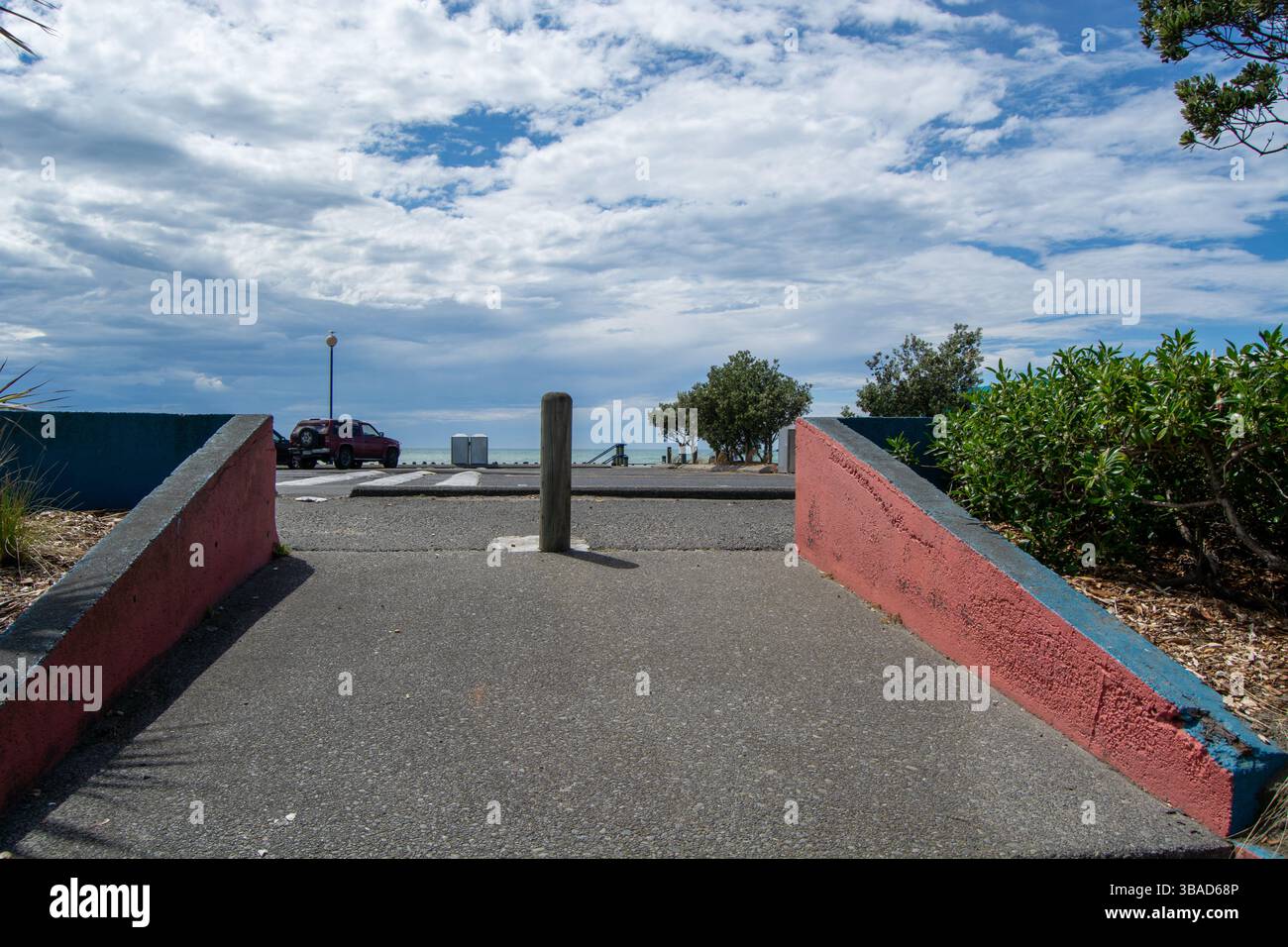 A view of a pathway leading to a beach, with a concrete pole in the ...