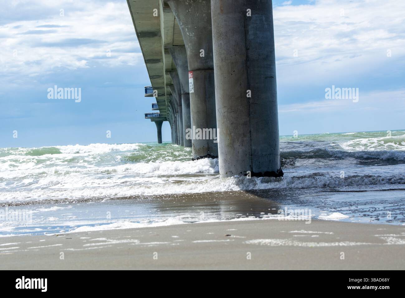 A view of a pier extending over the ocean, supported by concrete ...
