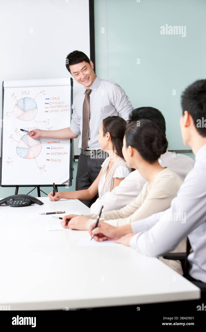 Chinese business executive presenting to business team Stock Photo - Alamy