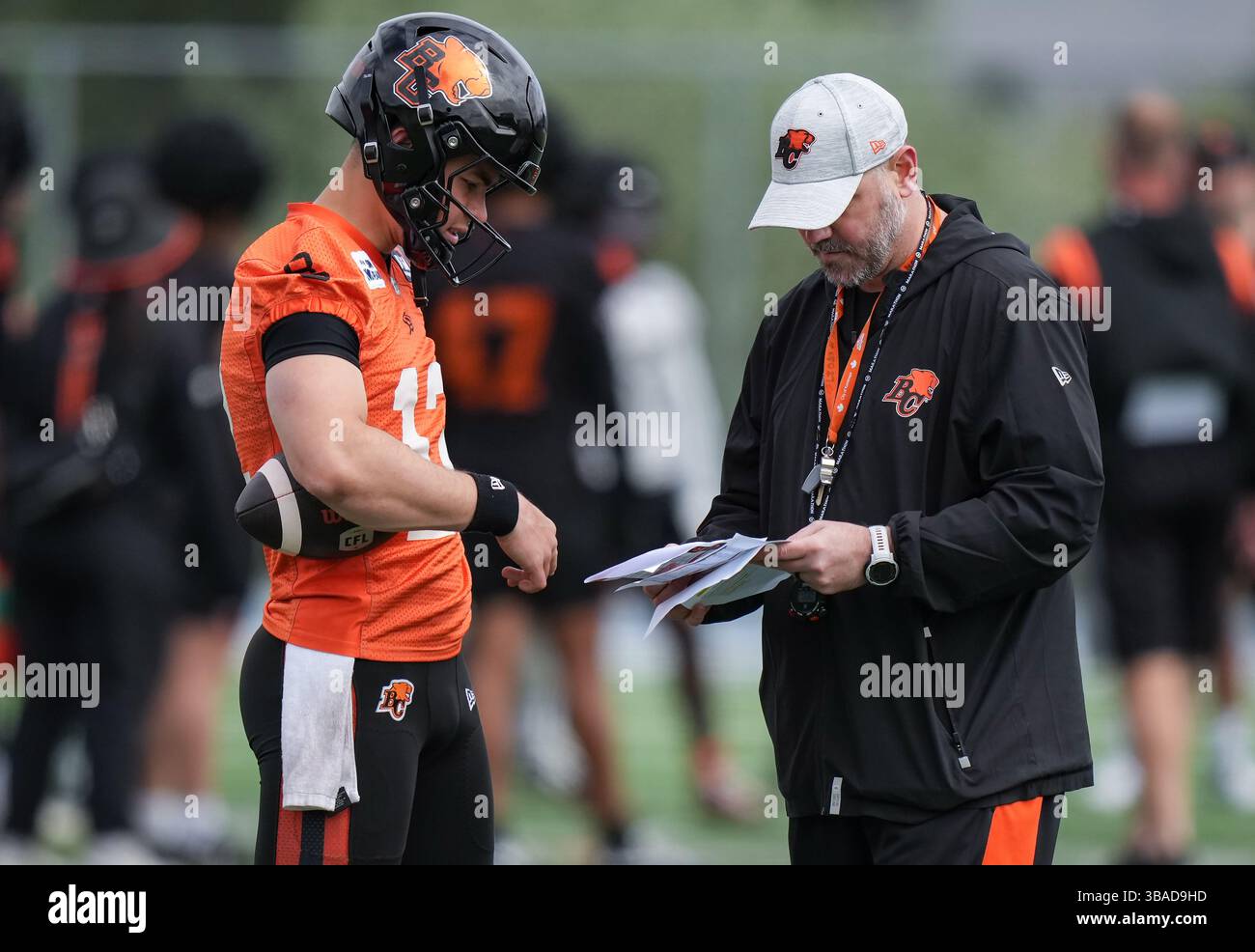 Kamloops, Canada. 12th May, 2025. B.C. Lions quarterback Nathan Rourke, left, listens to head ...
