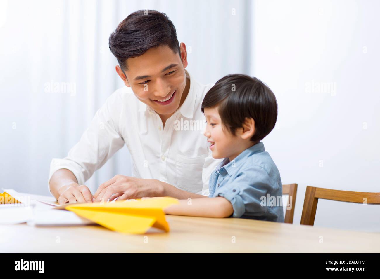 Chinese father an son making paper plane Stock Photo - Alamy
