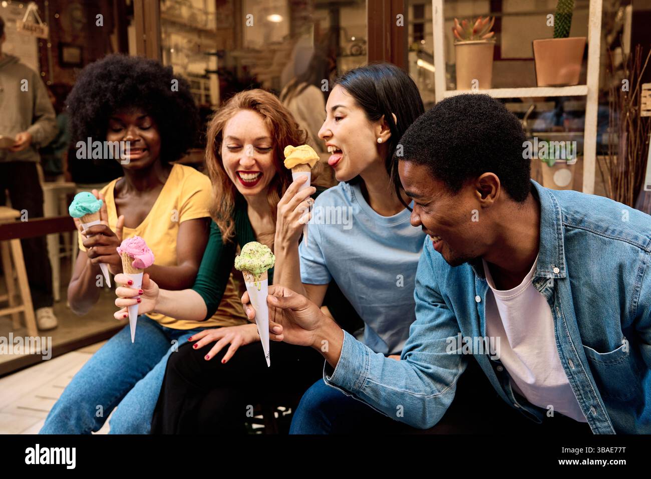 Group of friends licking ice cream sitting in the street Stock Photo ...