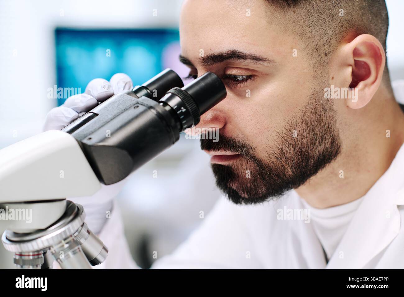 Part of face of young male researcher with microscope studying new ...