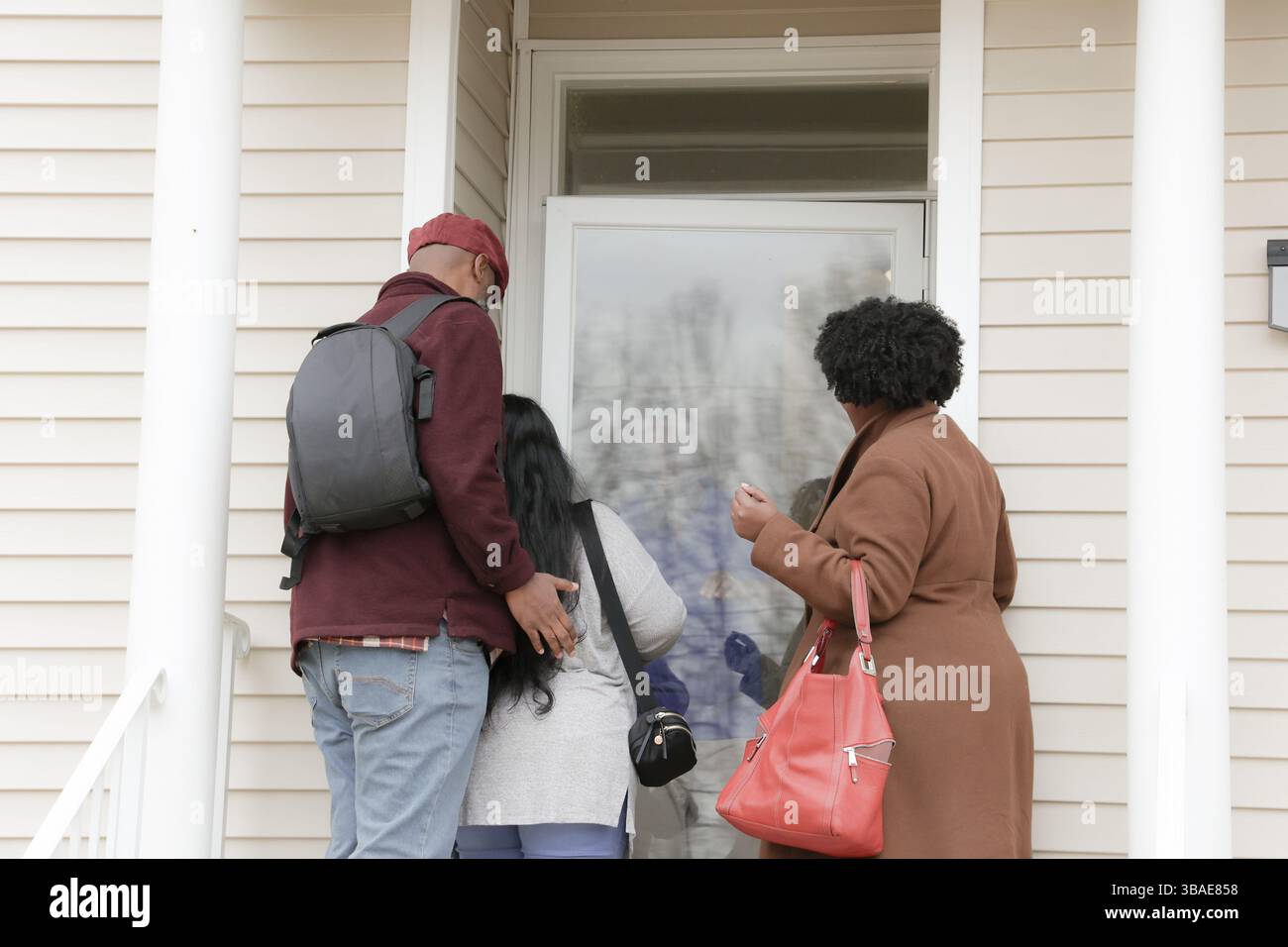 Group of middle aged friends standing outside the front door of their ...