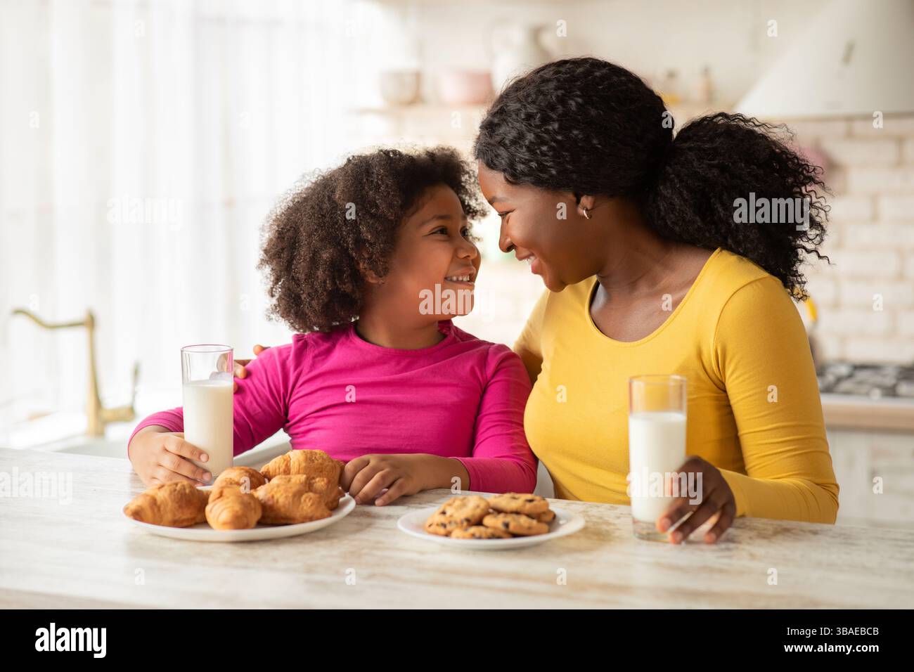 Happy Black Mother And Daughter Bonding Together While Having Snacks In Kitchen, Cheerful ...