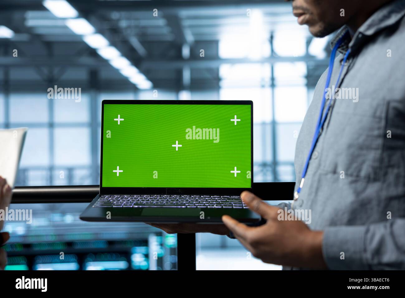 Employees in data center using isolated screen mockup laptop, integrating green technologies. IT ...