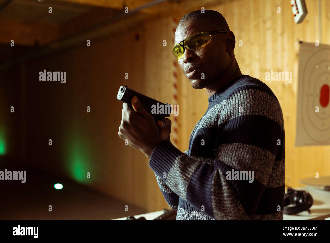 Firing range client holding pistol enjoying recreational indoor ...