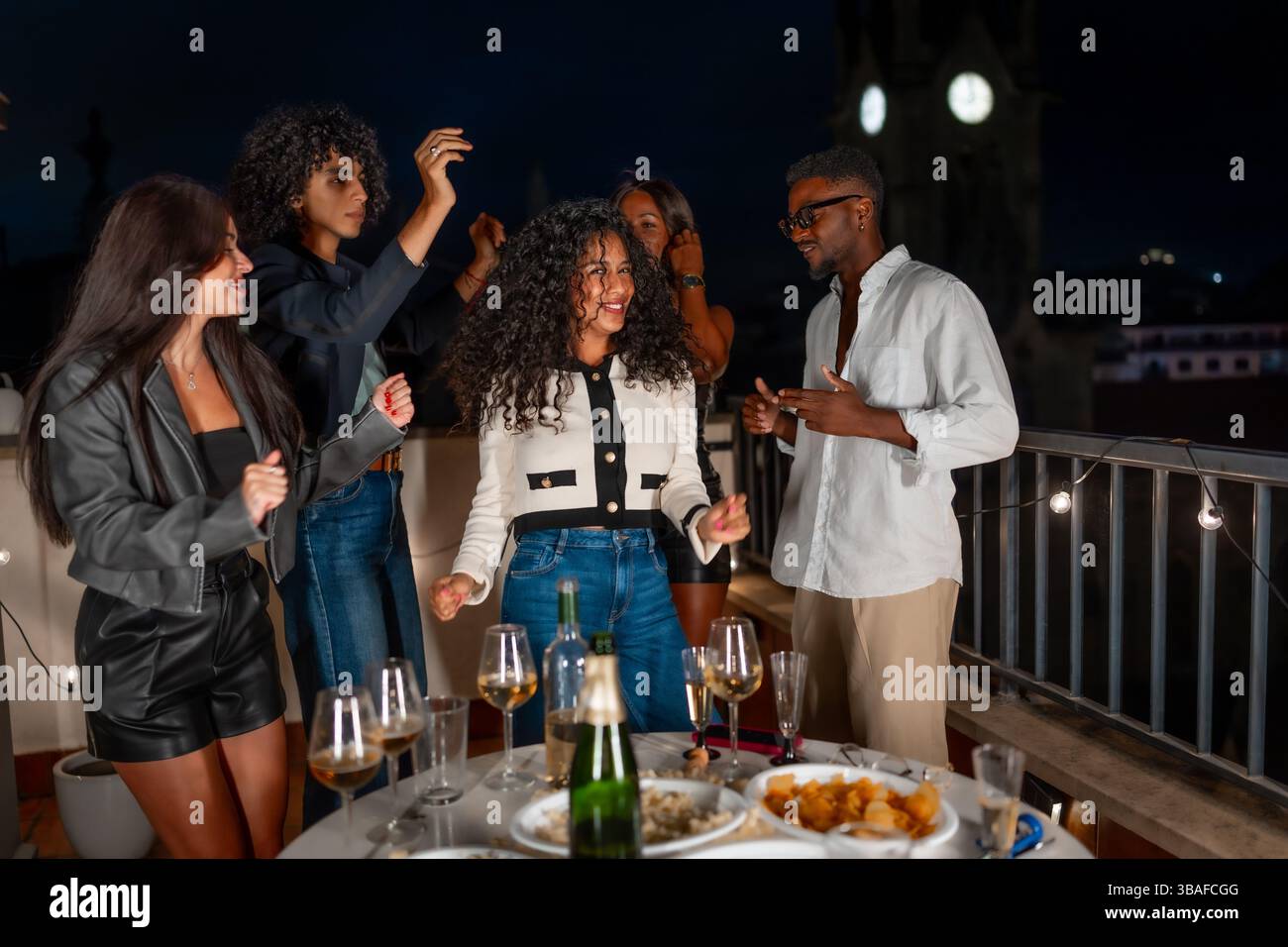 Diverse group of friends drinking alcohol and dancing together partying ...