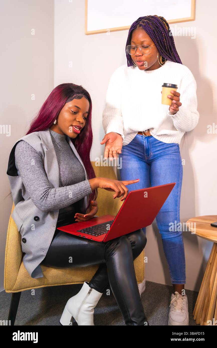 Young Black women working together on laptop in hotel room Stock Photo ...