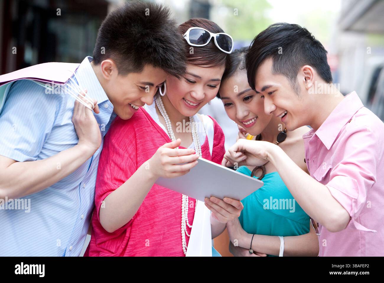 Four Chinese friends using tablet Stock Photo - Alamy