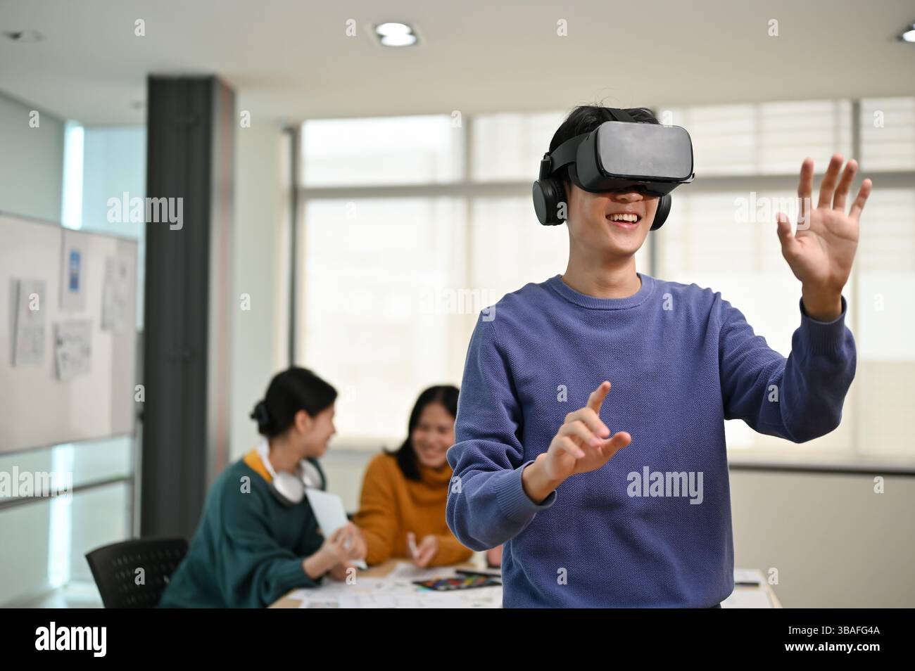 A cheerful and excited young Asian male developer tested a new VR game ...