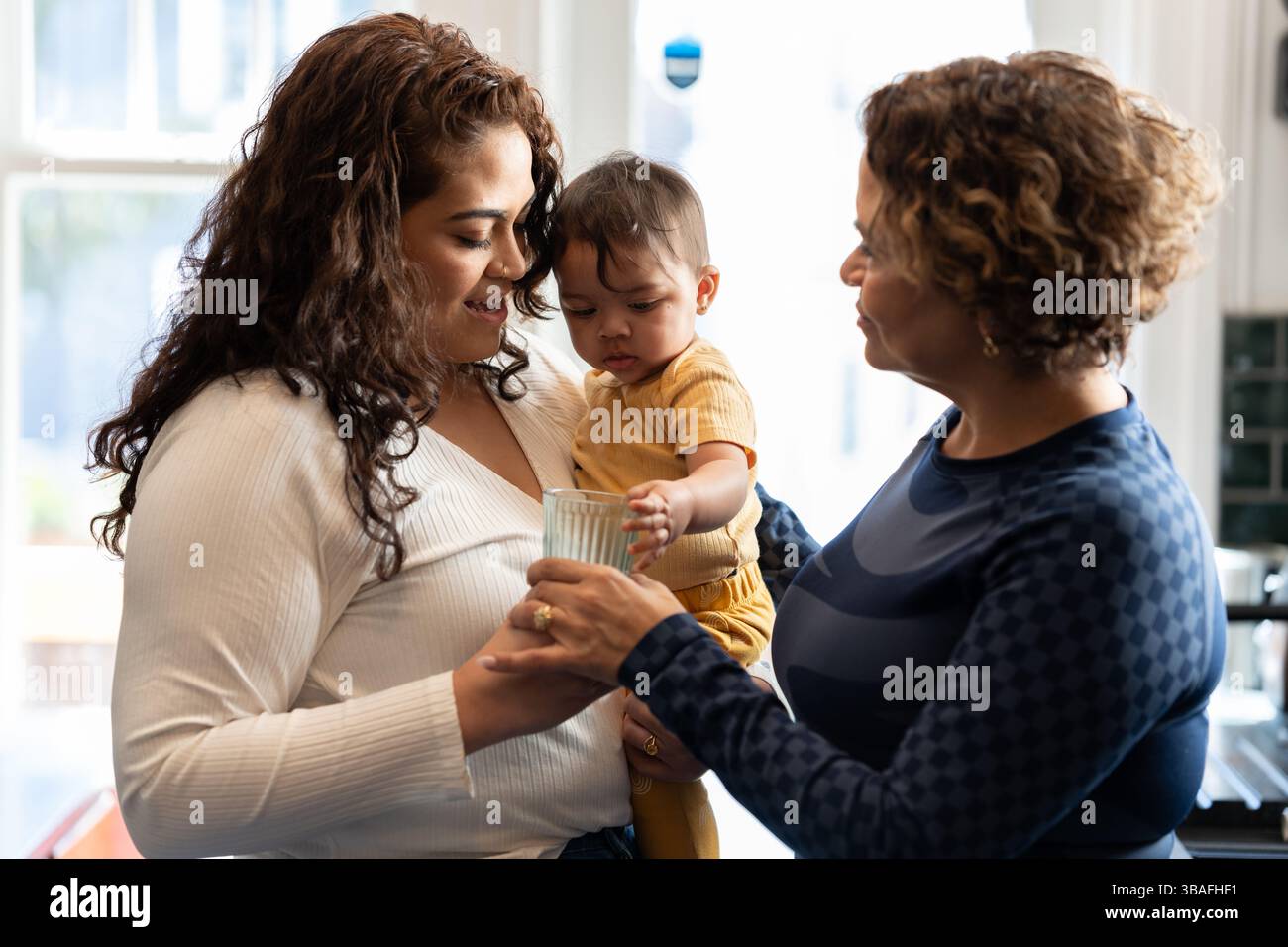 Middle-aged Hispanic woman with curly hair holding glass with water ...