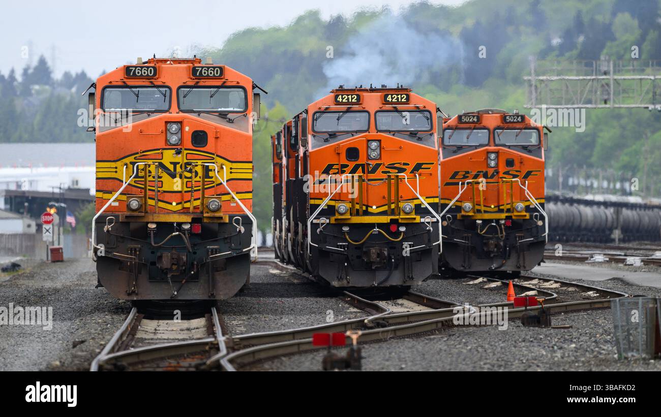 Seattle - April 27, 2025; Three BNSF freight trains with orange locomotives in brand colors ...
