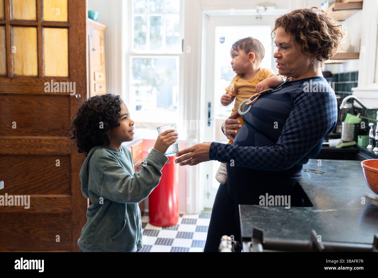Middle-aged Hispanic woman with curly hair carrying her mixed race ...