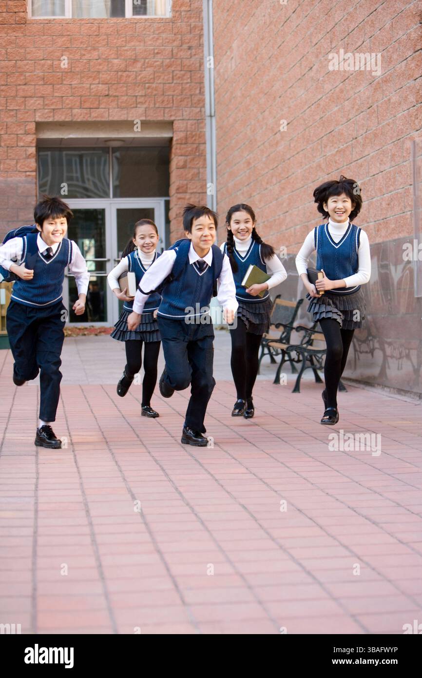 Five Chinese classmates running through campus Stock Photo - Alamy