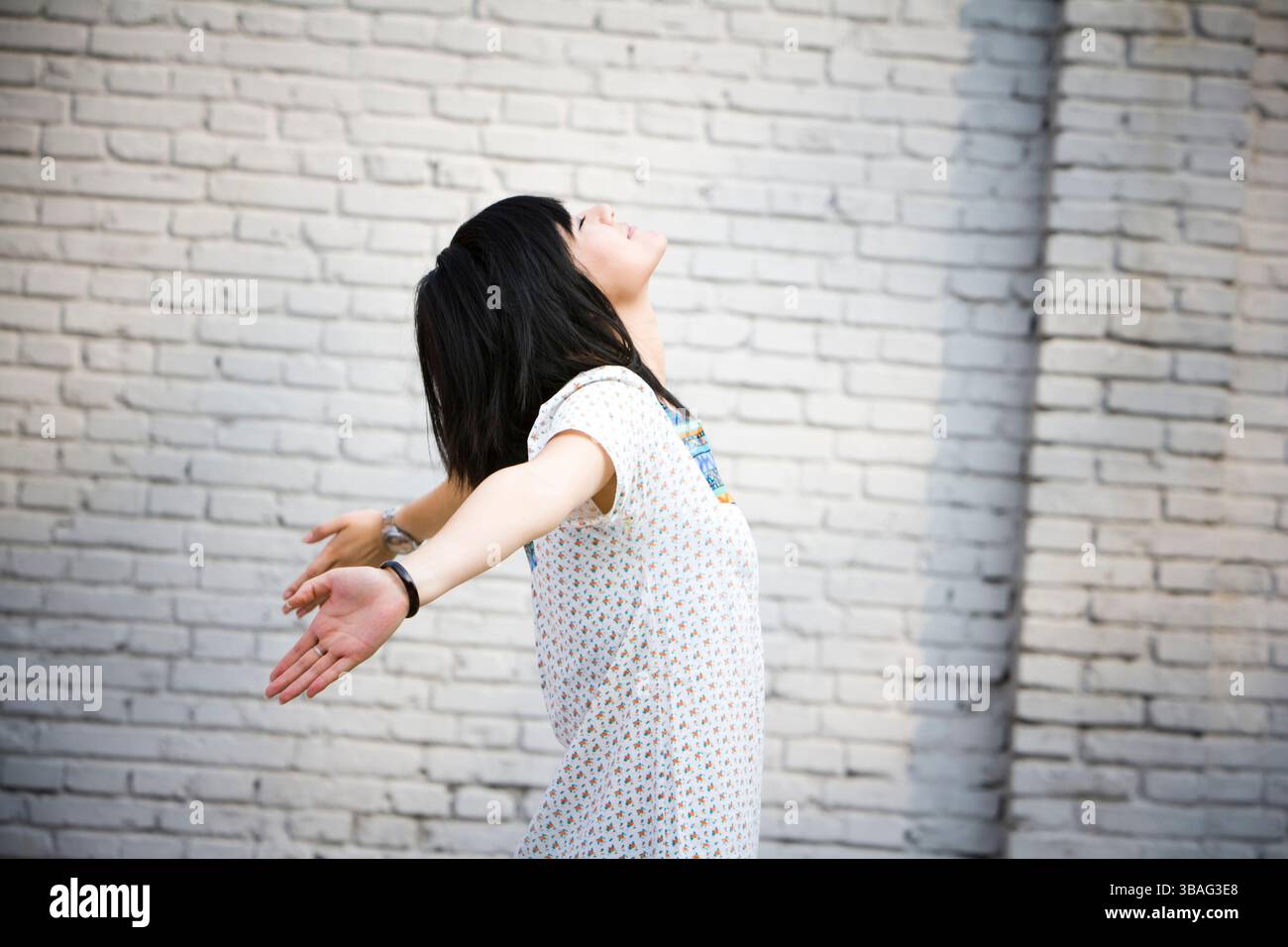 Young Chinese woman arms outstretched Stock Photo - Alamy
