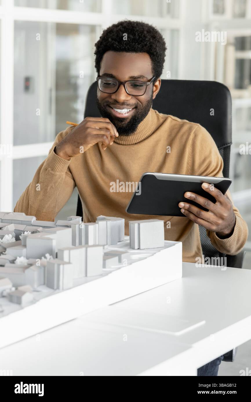 Architect at work. African american architect working in his office and ...